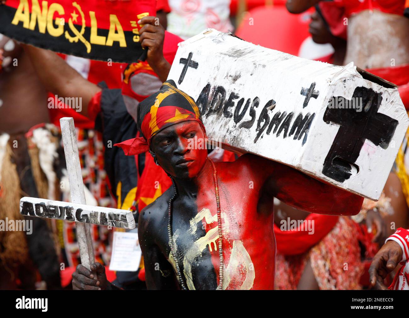 An Angola fan painted in the colors of the Angola flag carries a coffin ...