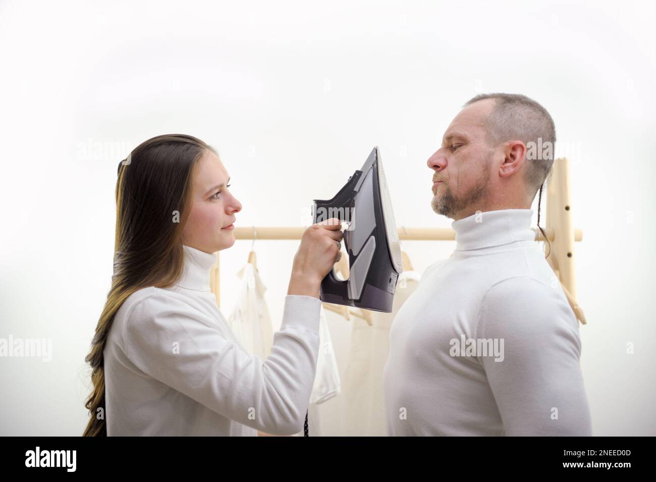 threatening with iron young girl shows iron to adult man in front of ...