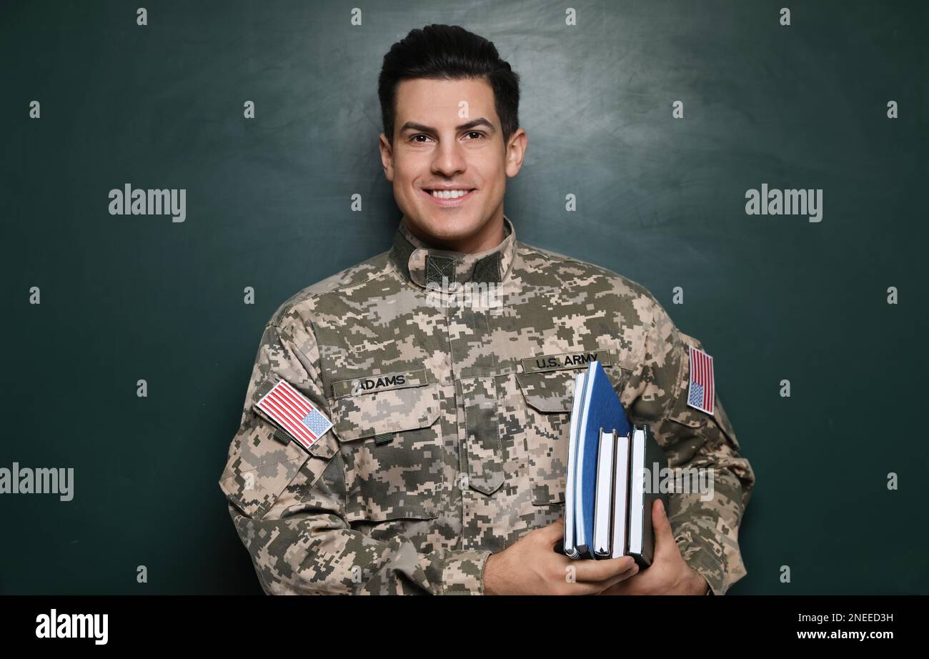 Cadet with books near chalkboard. Military education Stock Photo - Alamy