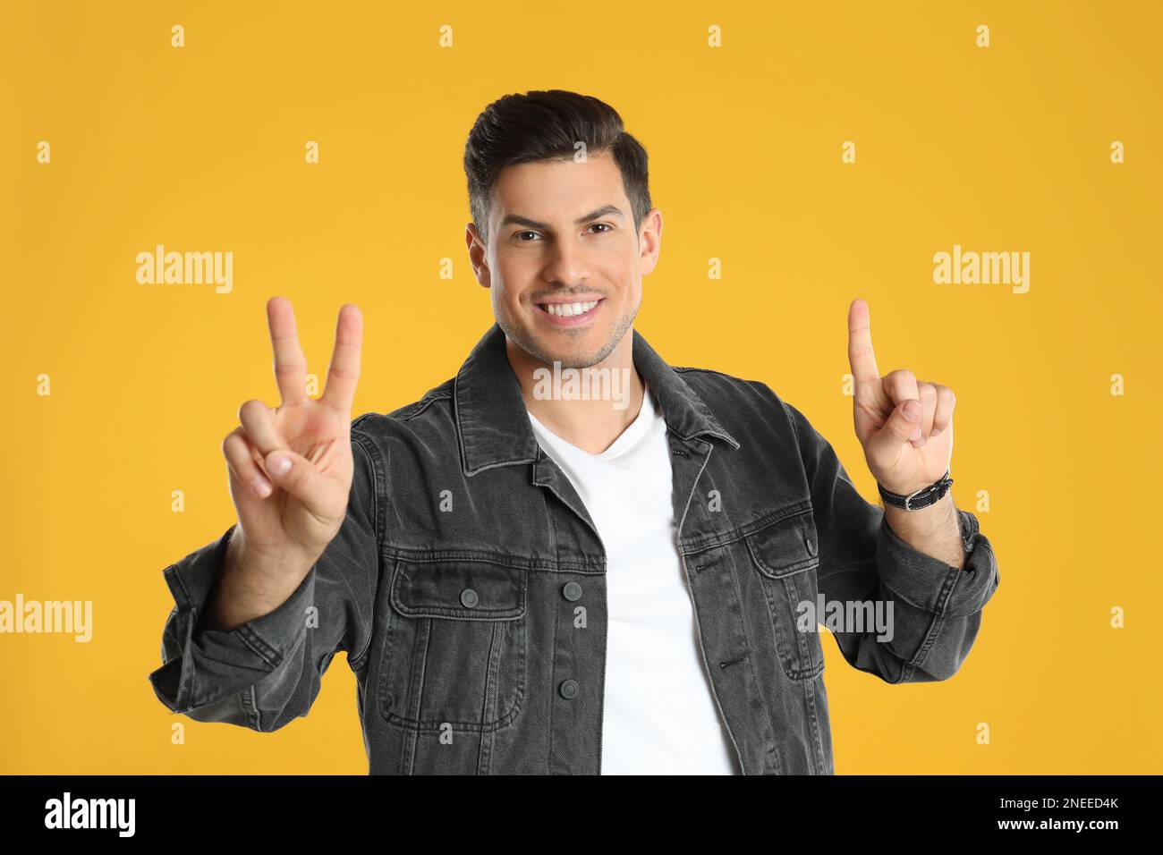 Man showing number three with his hands on yellow background Stock ...