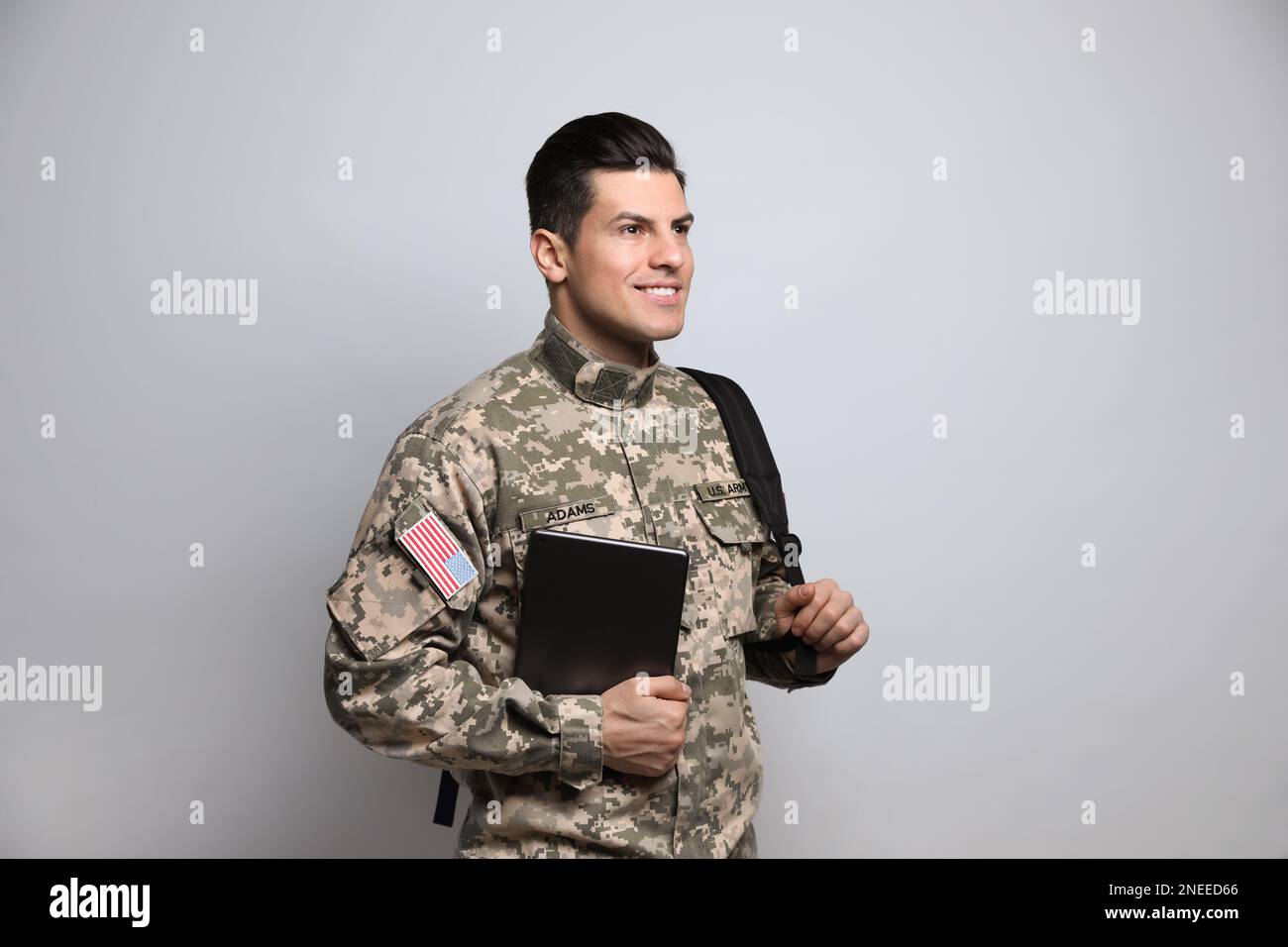 Cadet with backpack and tablet on light grey background. Military ...