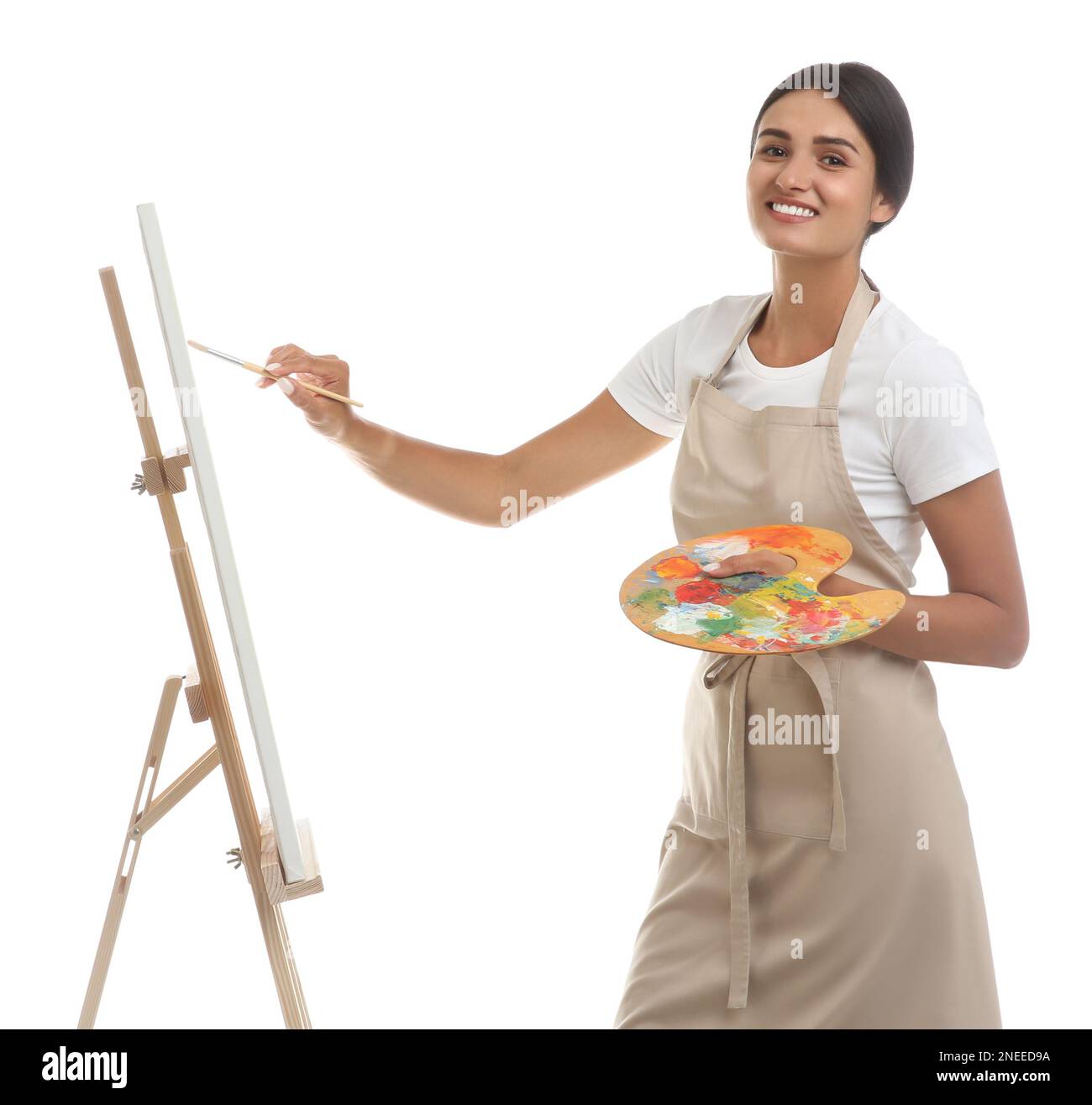 Young woman drawing on easel against white background Stock Photo - Alamy