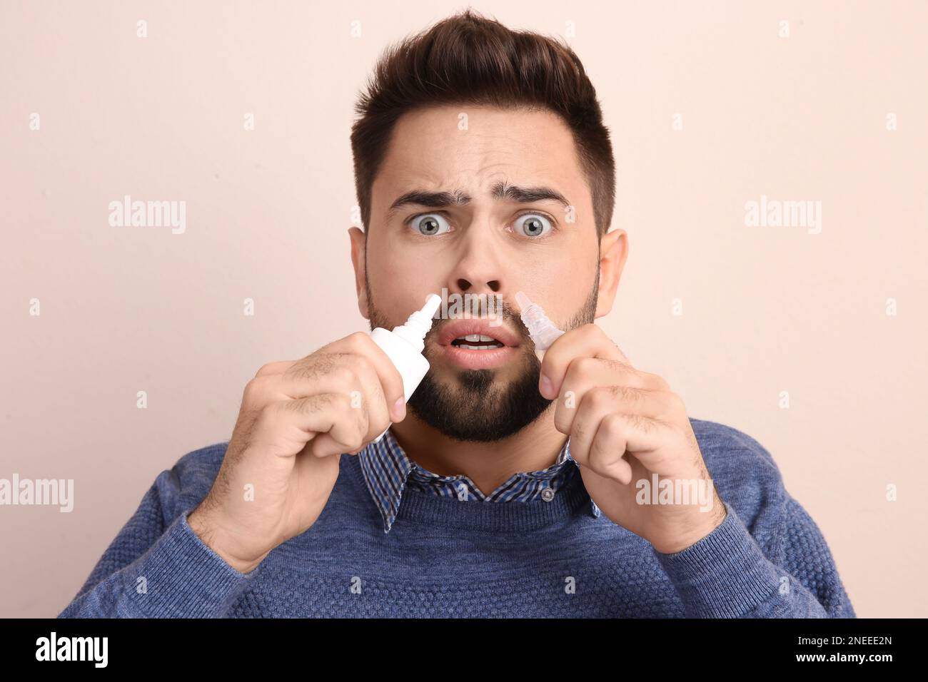 Man using nasal sprays on beige background Stock Photo - Alamy