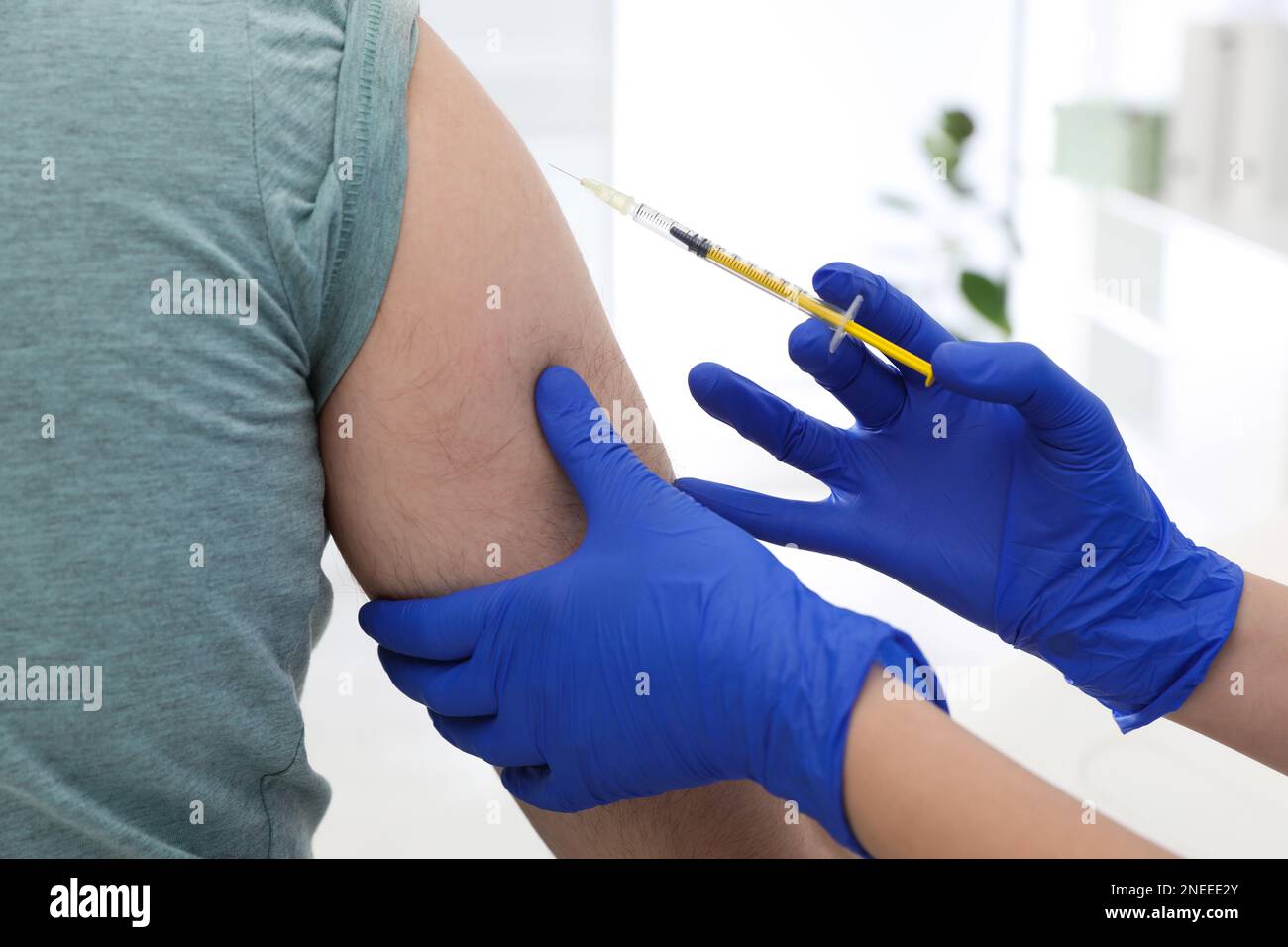 Doctor giving injection to man in hospital, closeup. Immunization ...