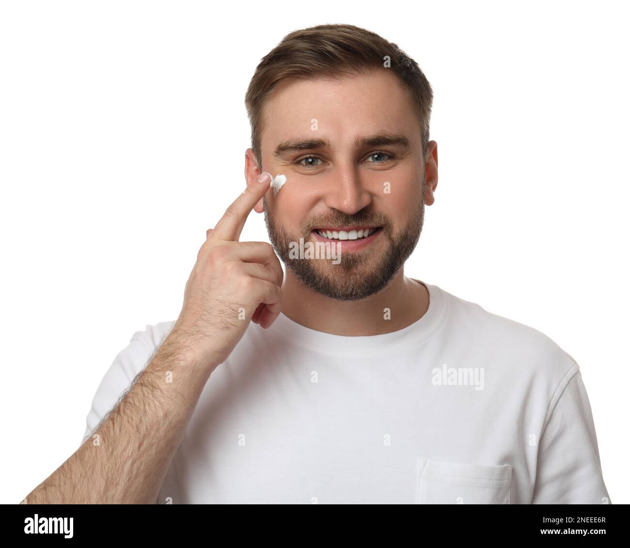 Happy young man applying facial cream on white background Stock Photo ...