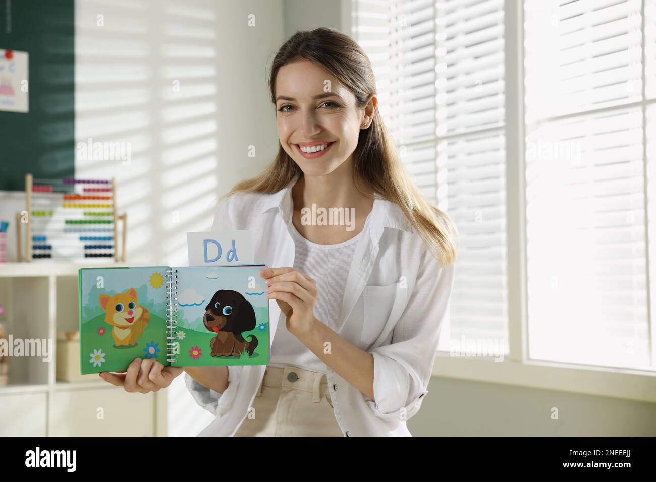 Happy female English teacher giving lesson in elementary school Stock ...