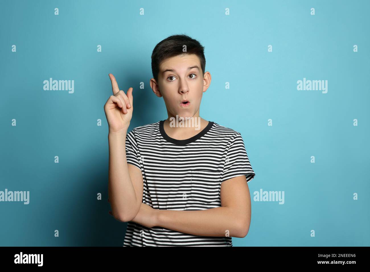 Emotional teenage boy on light blue background Stock Photo - Alamy