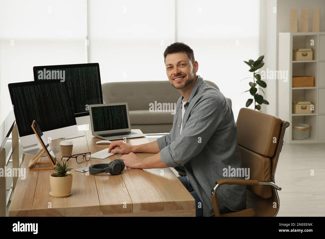 Happy programmer working at desk in office Stock Photo - Alamy
