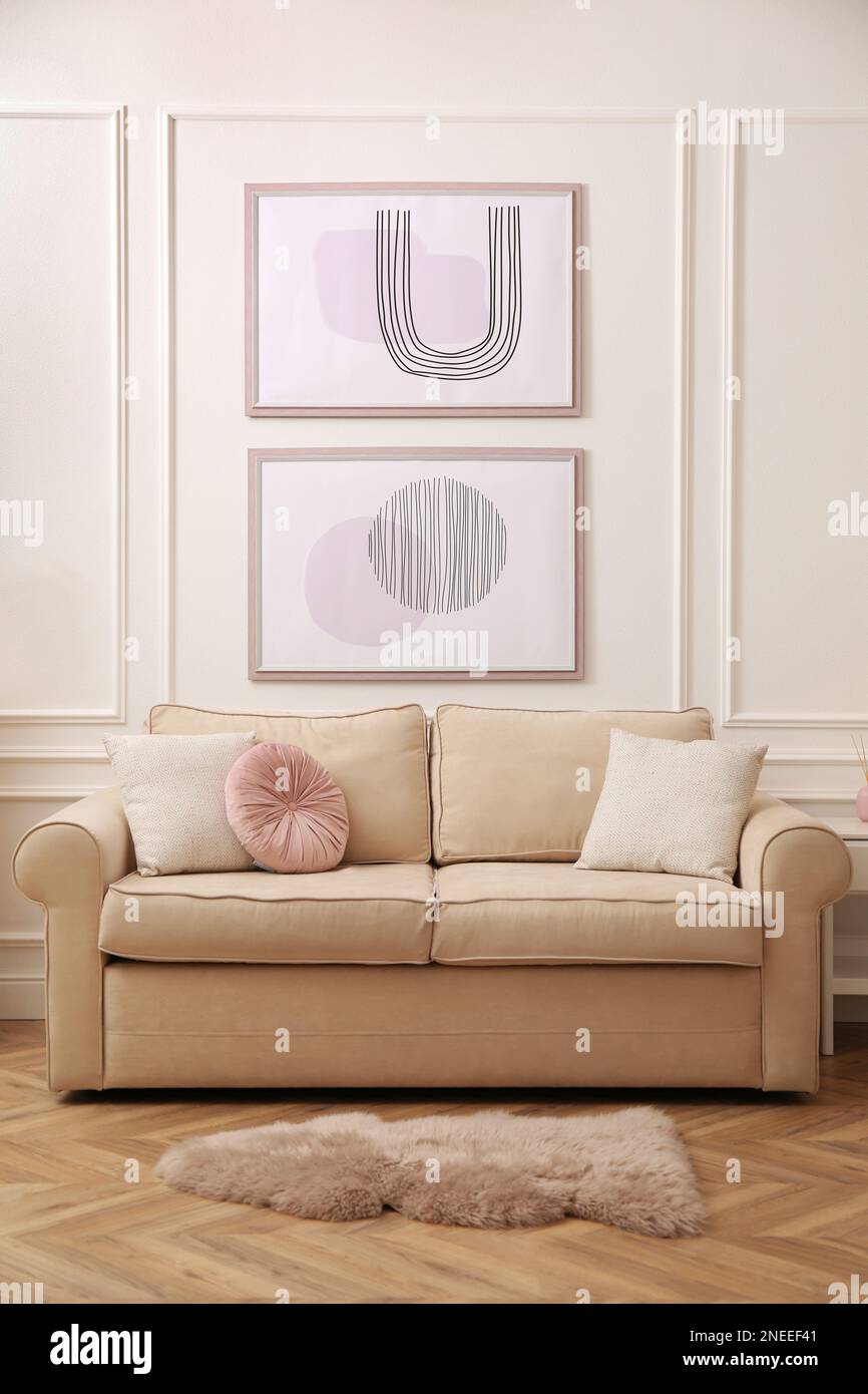 Stylish living room interior with comfortable sofa and pictures Stock ...