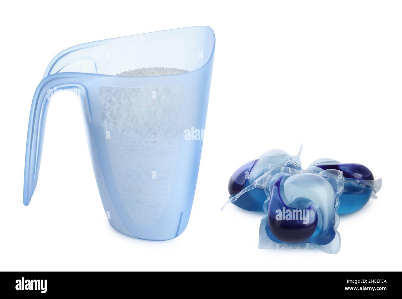 Laundry capsules and measuring cup of washing powder on white ...