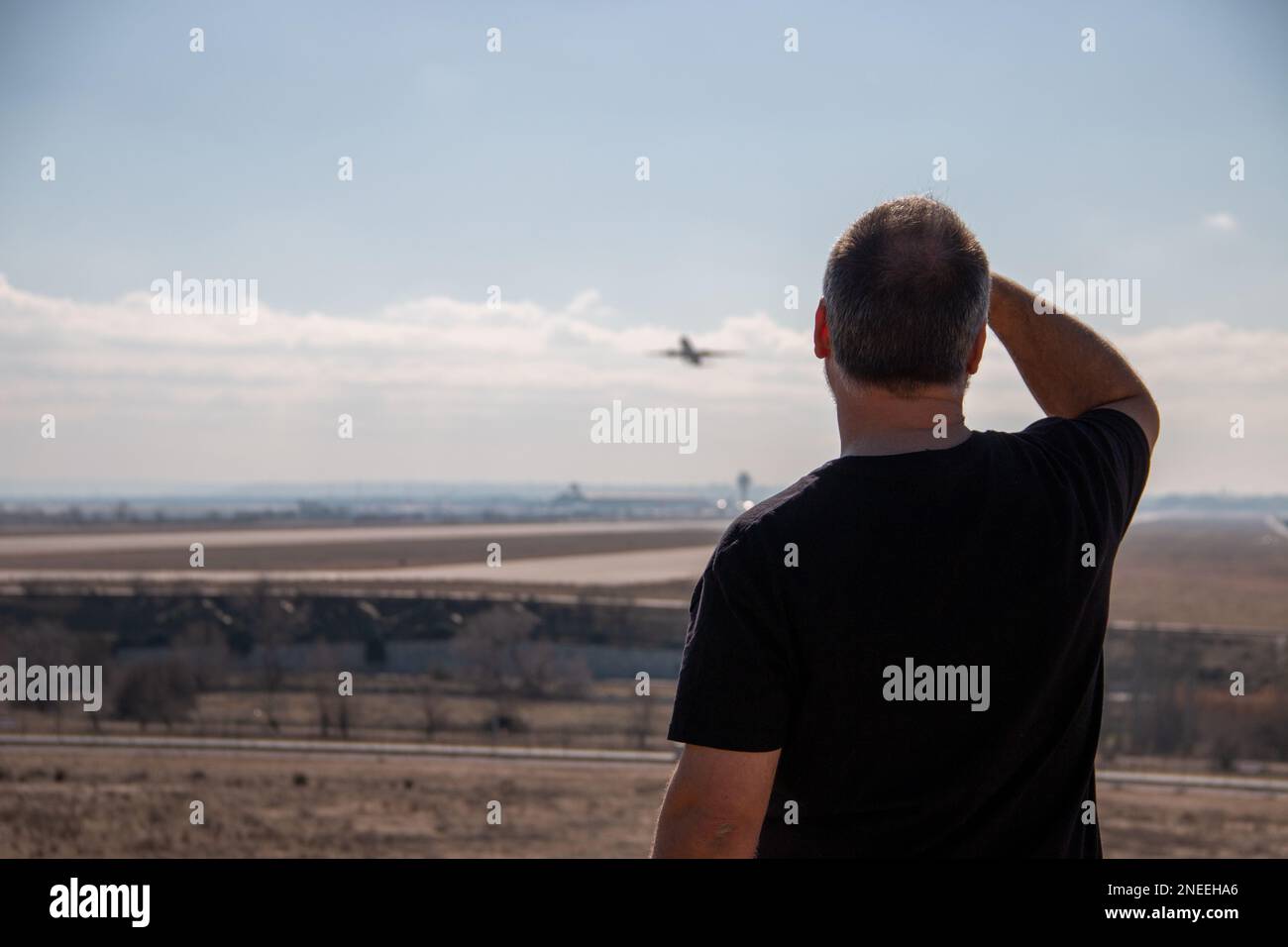 Slightly bald adult man dressed in black watching and pointing as ...