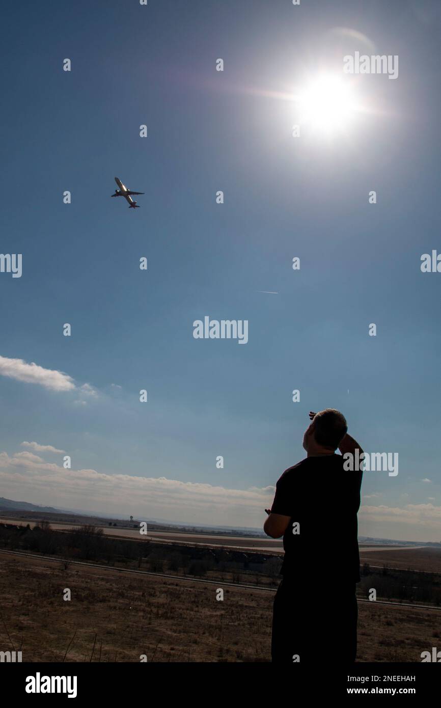 Slightly bald adult man dressed in black watching and pointing as ...