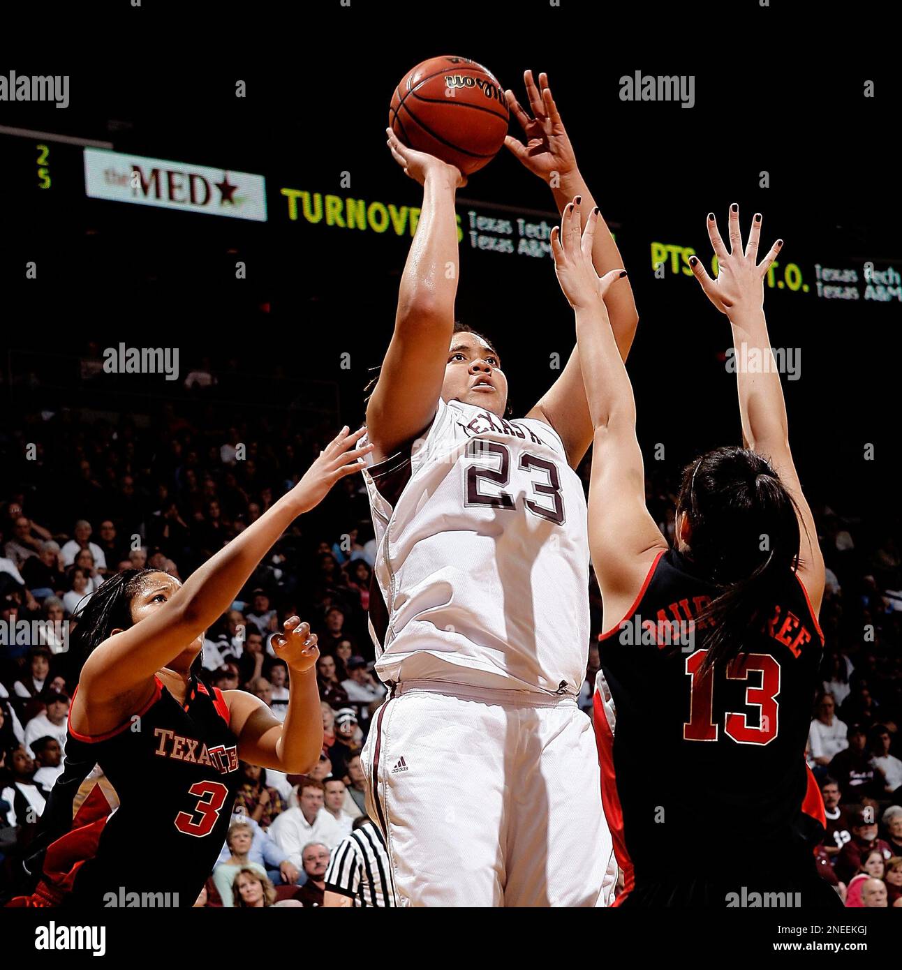 Texas A&M's Danielle Adams (23) shoots between the defense of Texas ...