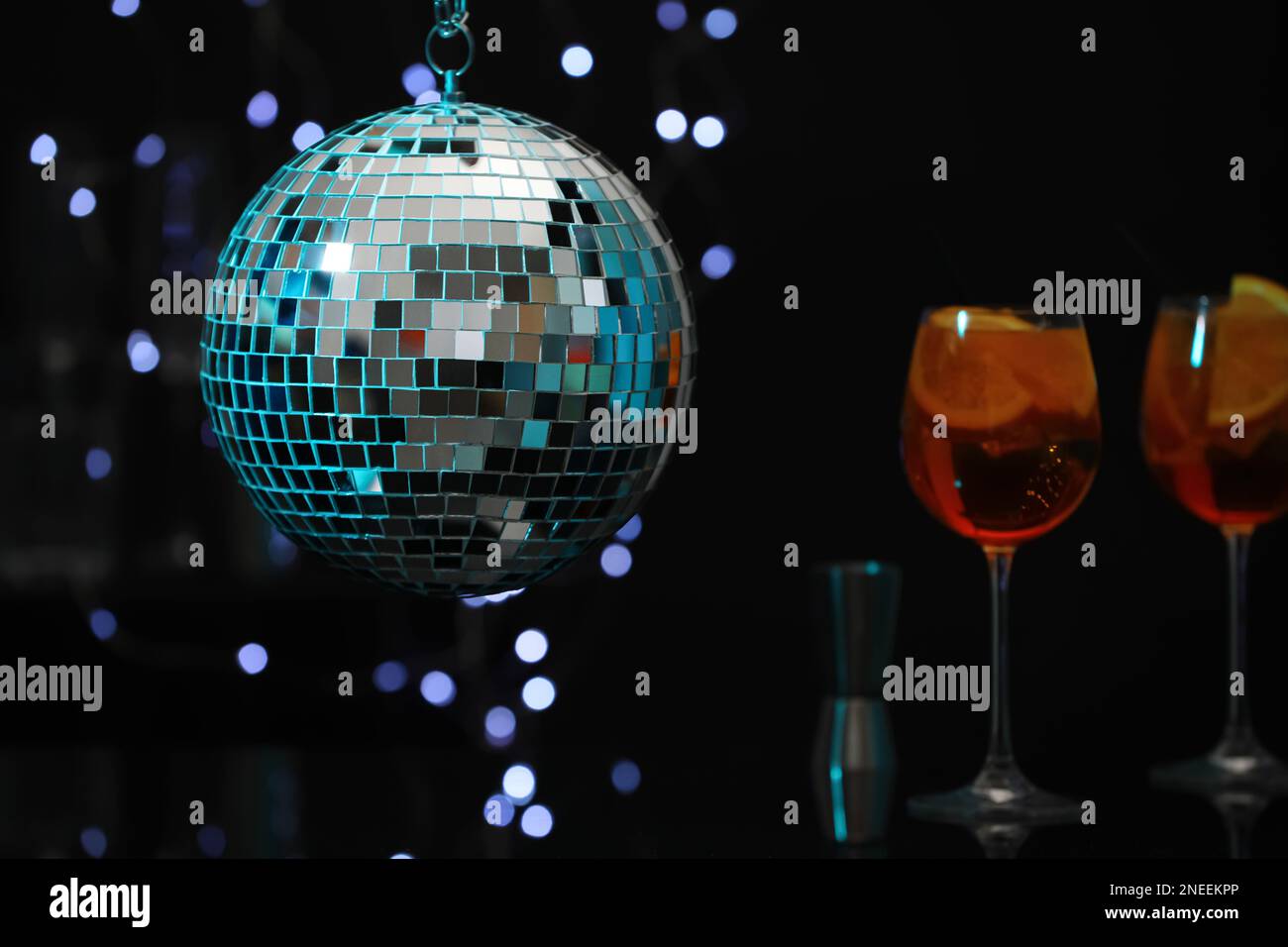 Shiny disco ball hanging over bar counter with cocktails in nightclub ...