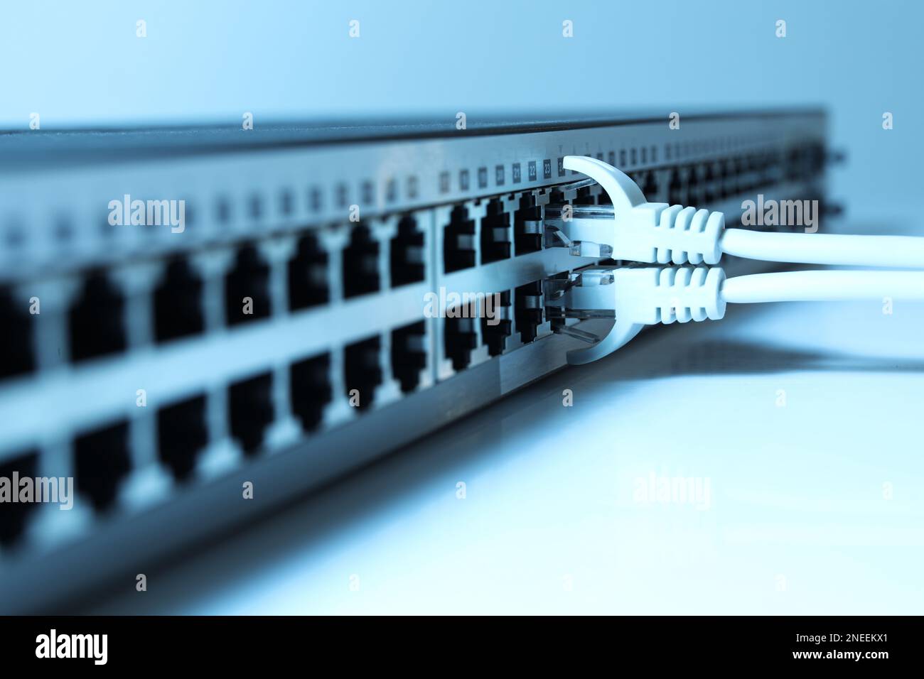 Closeup view of network switch with cables on light background, toned ...