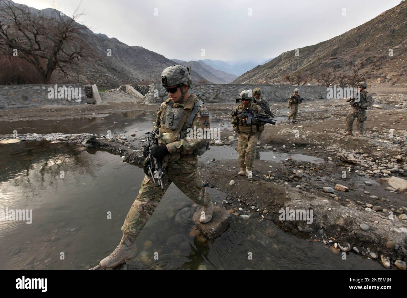 U.S. Army soldiers of the 2-12 Infantry cross a creek during a patrol ...