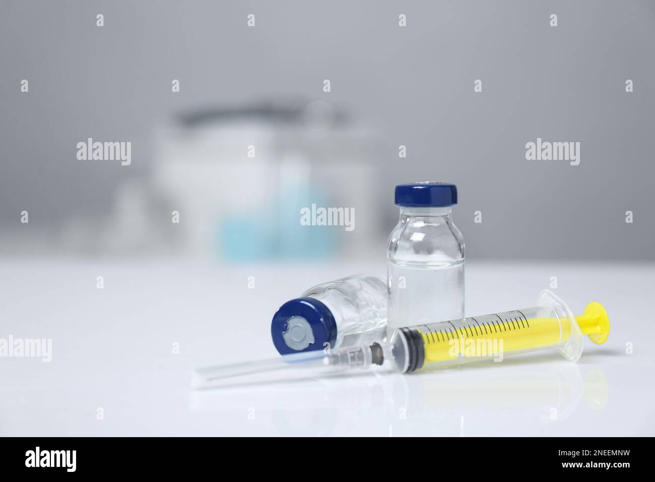 Syringe and vials on white table. Space for text Stock Photo - Alamy