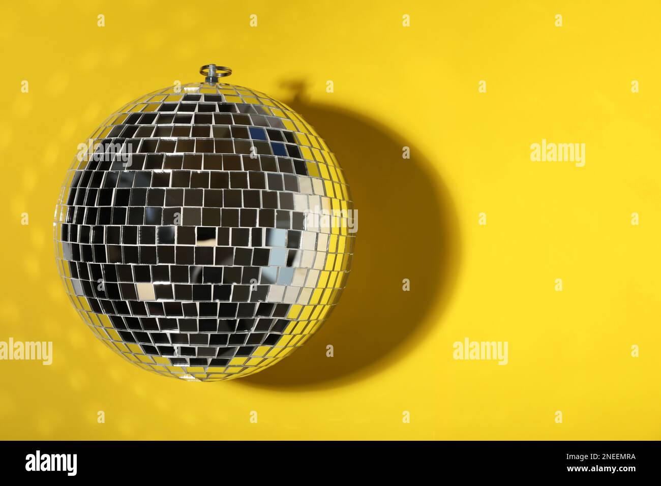 Shiny disco ball on yellow background, top view. Space for text Stock ...