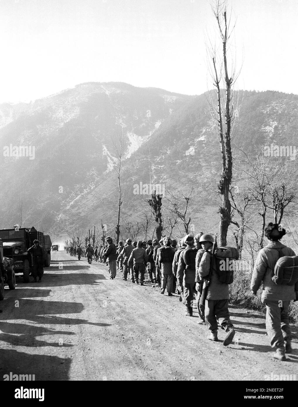 United Nations troops move in single file along a road in the Wonju ...