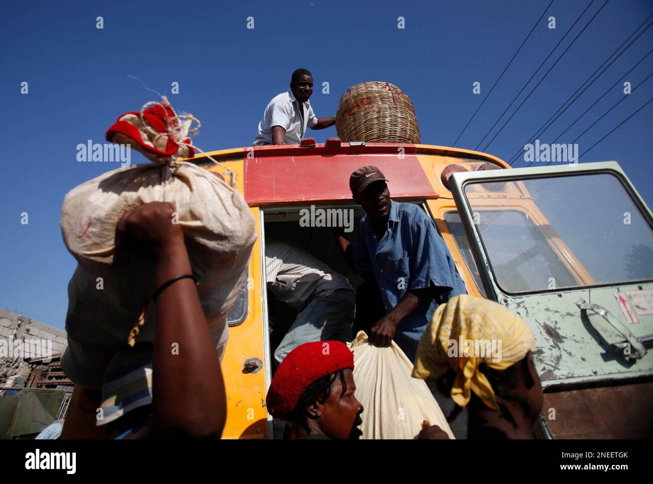 People load items on to a bus headed to St. Marc from Port-au-Prince ...