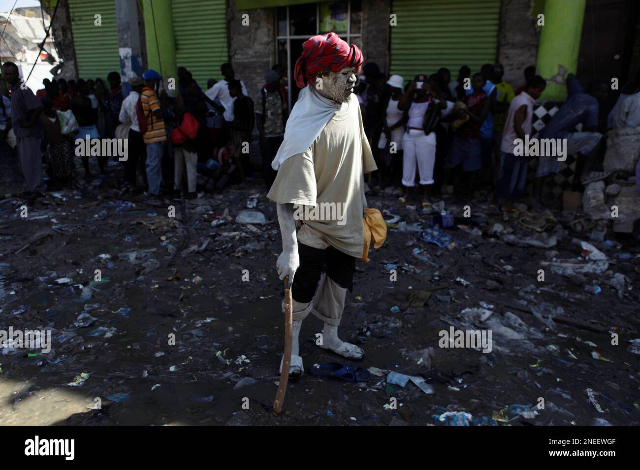 A man wears a cape and mud face paint as he walks in downtown Port-au ...