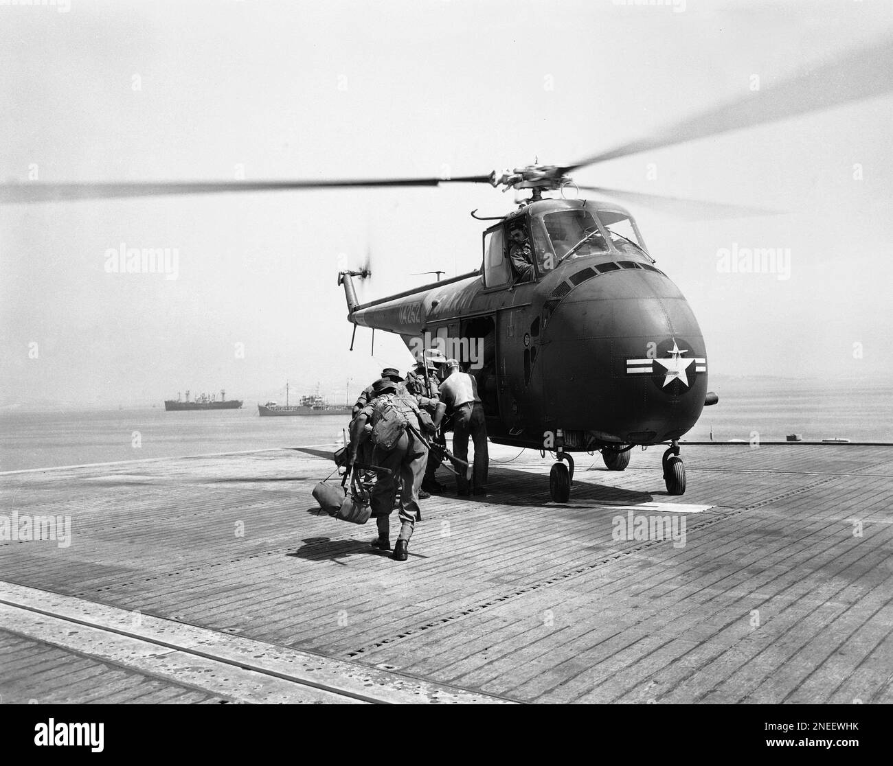 The Indian soldiers duck under the whirling rotors of the large ...