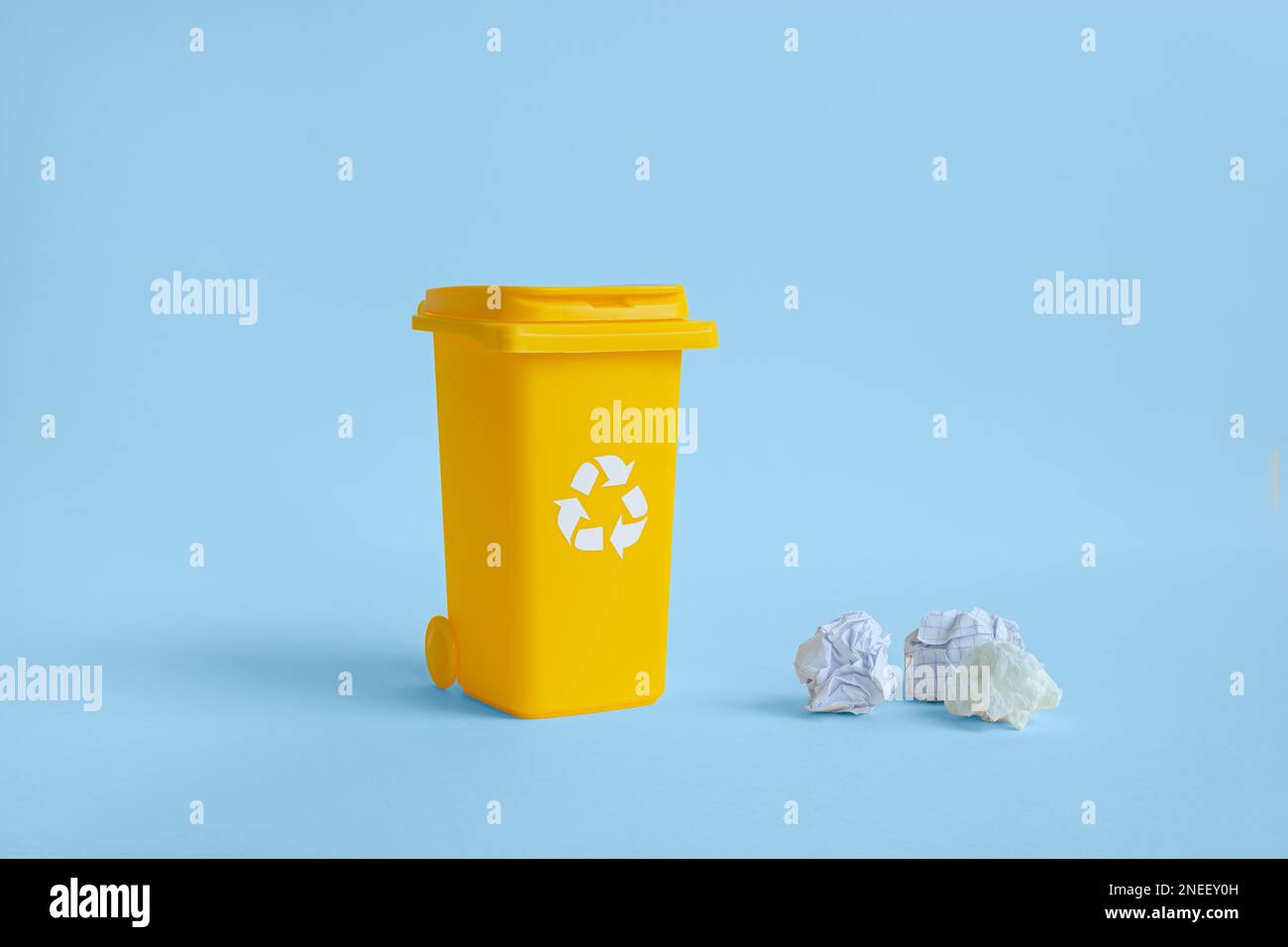 Yellow container for paper garbage collection and crumpled paper ...