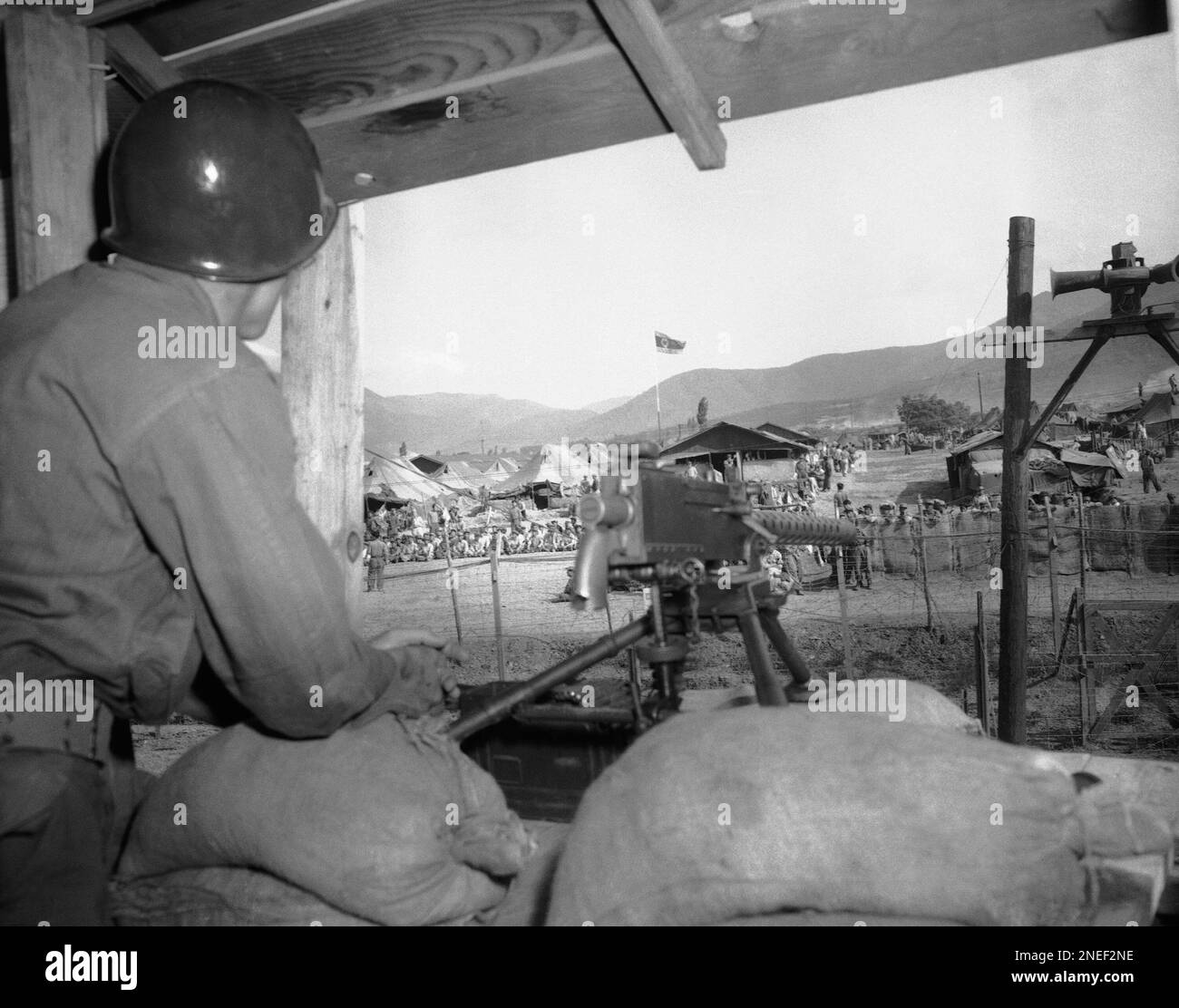 GI stands behind his machine gun in guard tower overlooking compound 62 ...