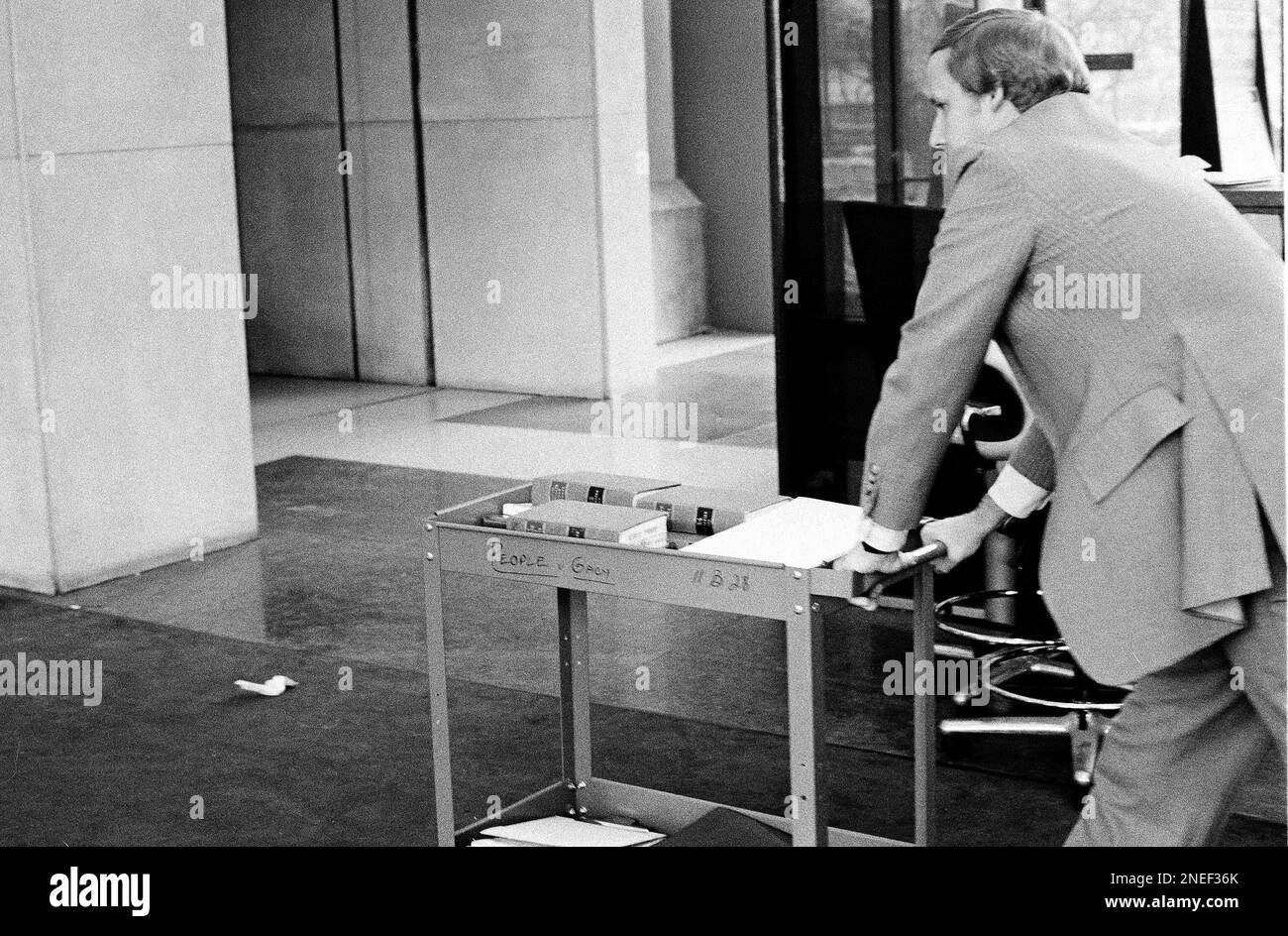 Assistant State?s Attorney Terry Sullivan pushes a cart leaded with ...