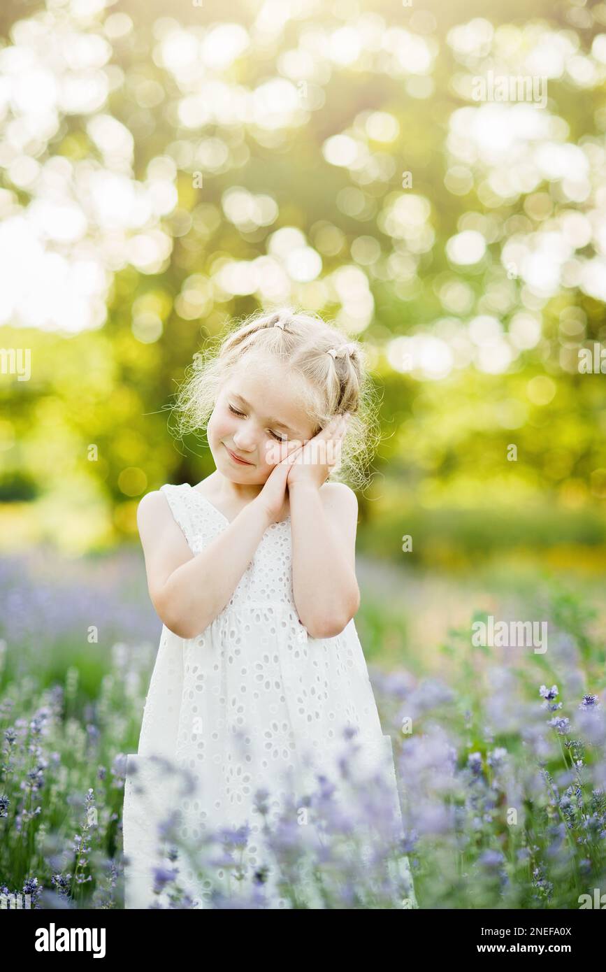 Little girl sniffing flowers hi-res stock photography and images - Alamy