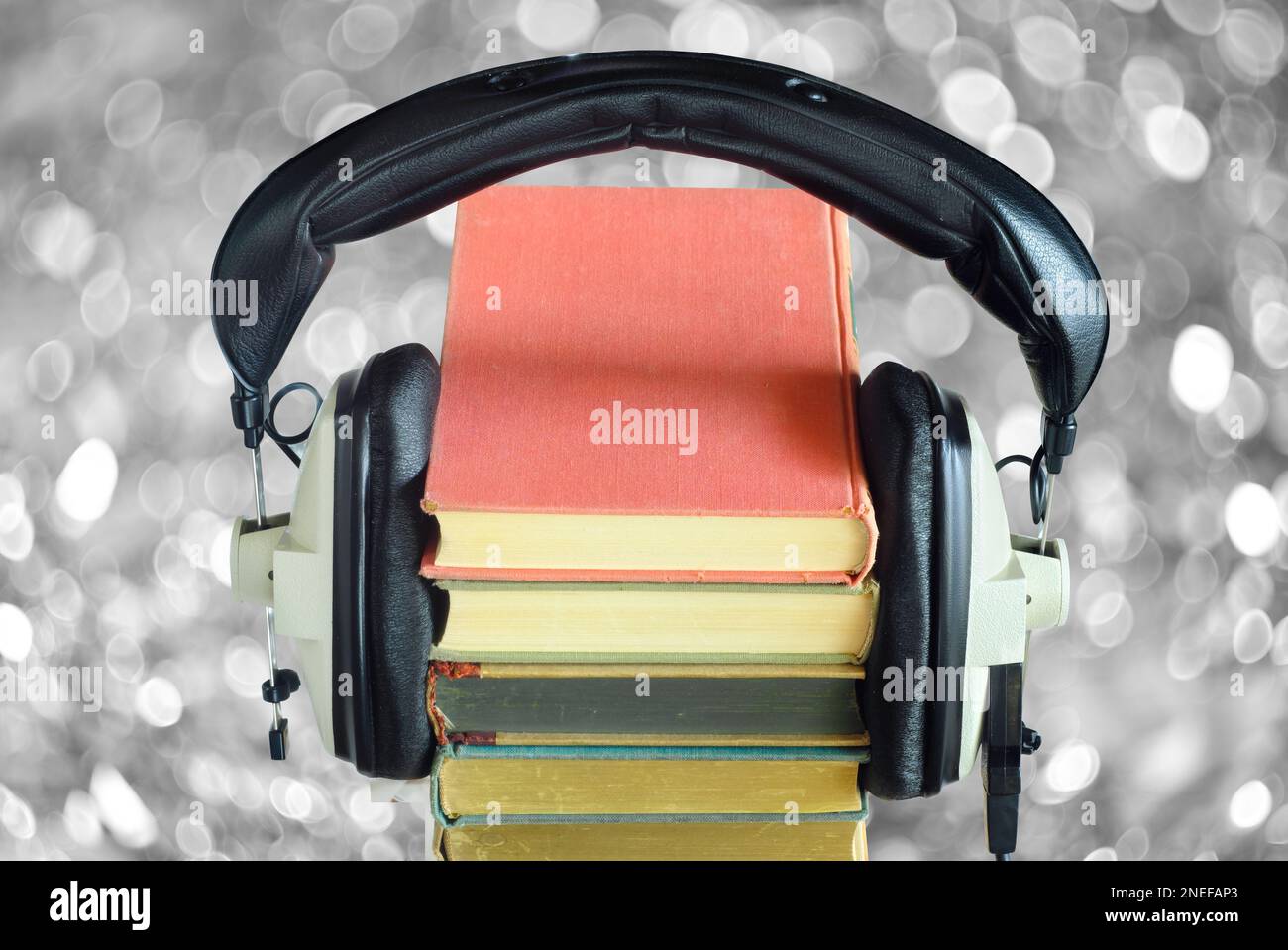 audio book concept with row of books, vintage headphones and bubble ...