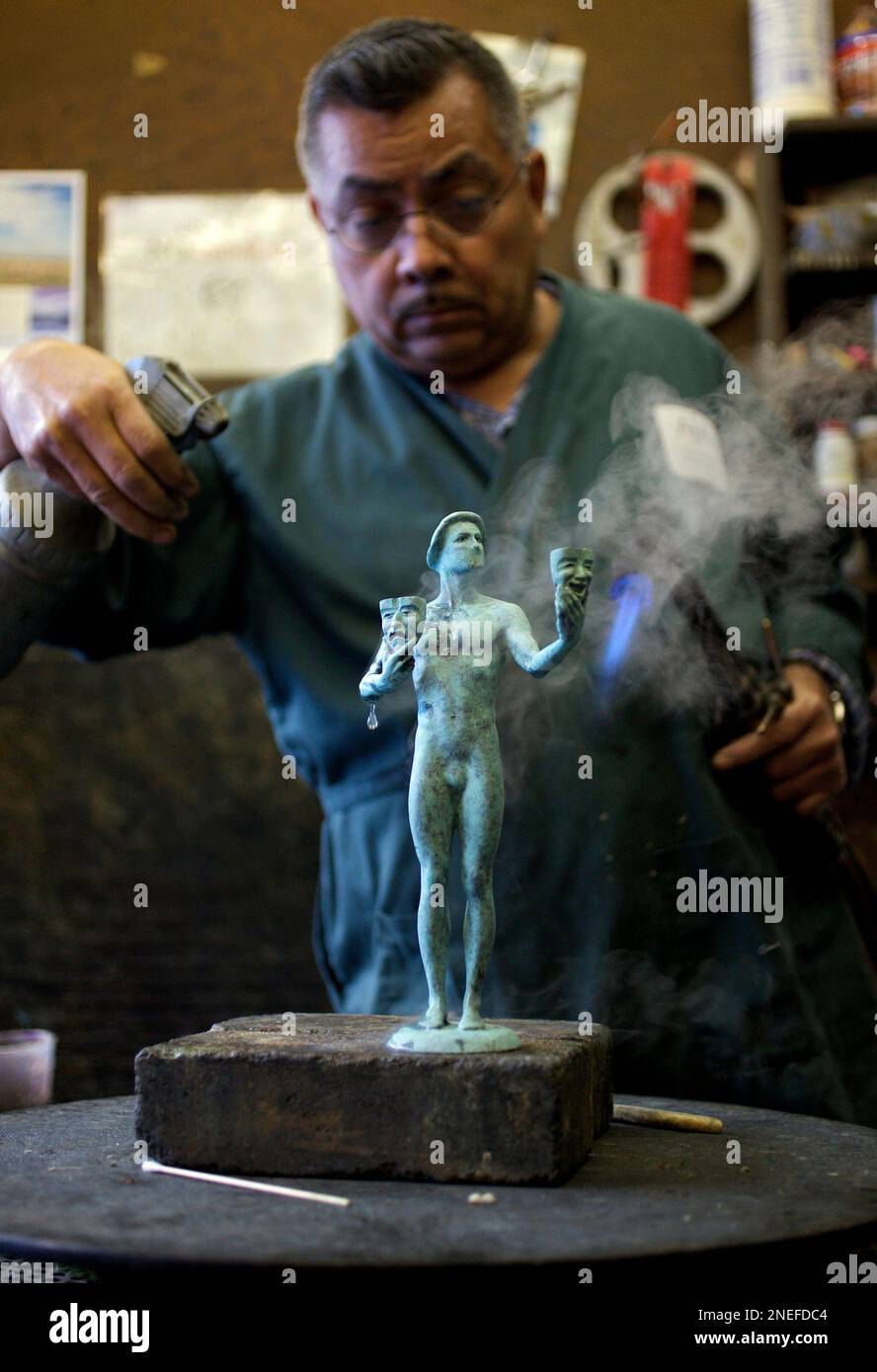 Artist Joaquin Quintero applies the finishing fire and chemical ...