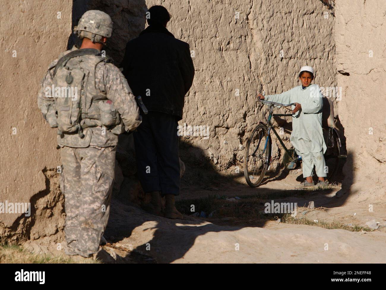 An Afghan boy looks towards a soldier from the 293rd Military Police ...