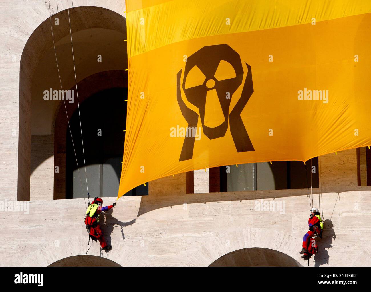 Greenpeace activists, dressed in orange jump suits, unroll a yellow ...