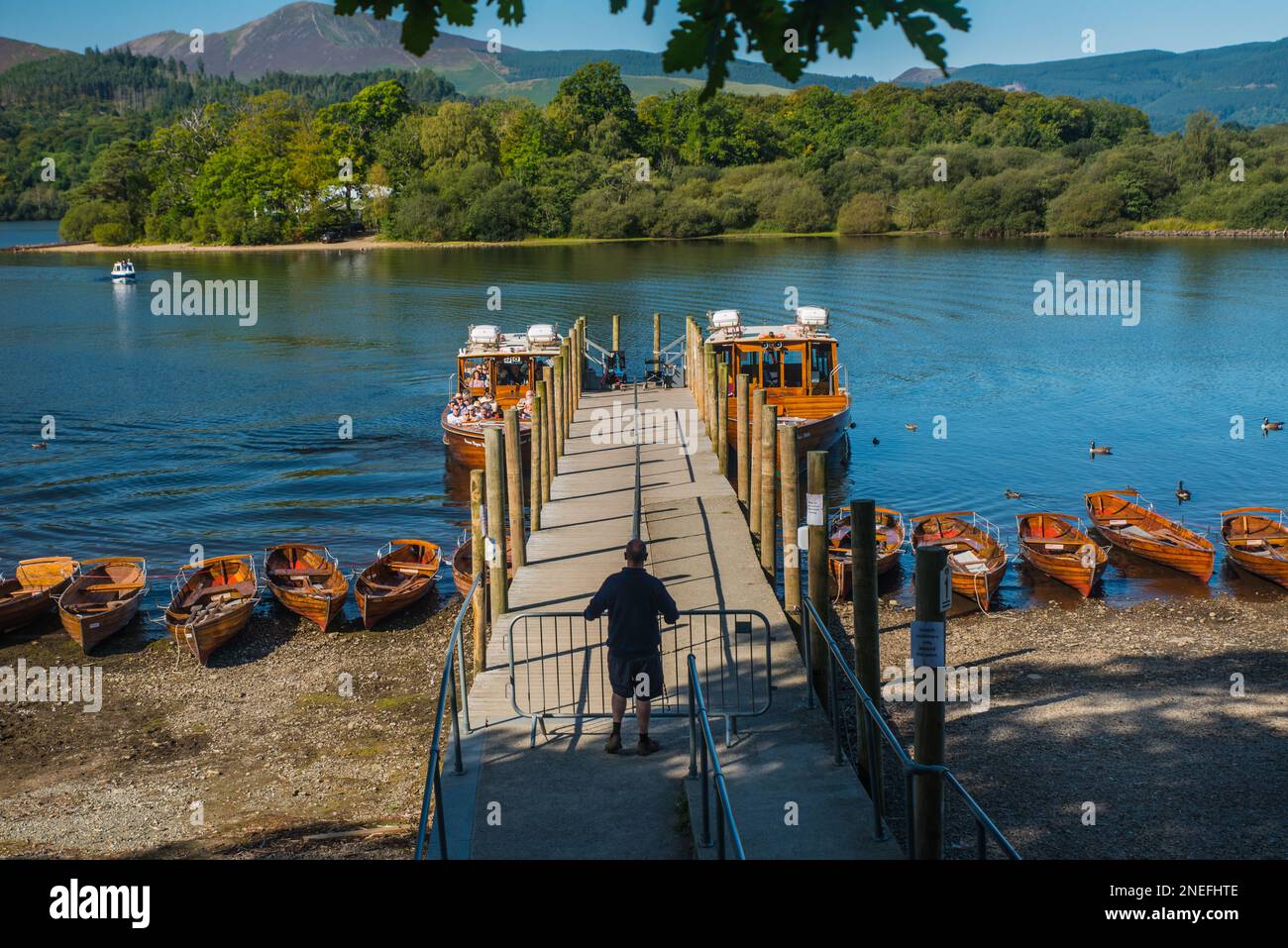 A symmetrical scene of Keswick boat launch on Derwent Water lake, Lake ...