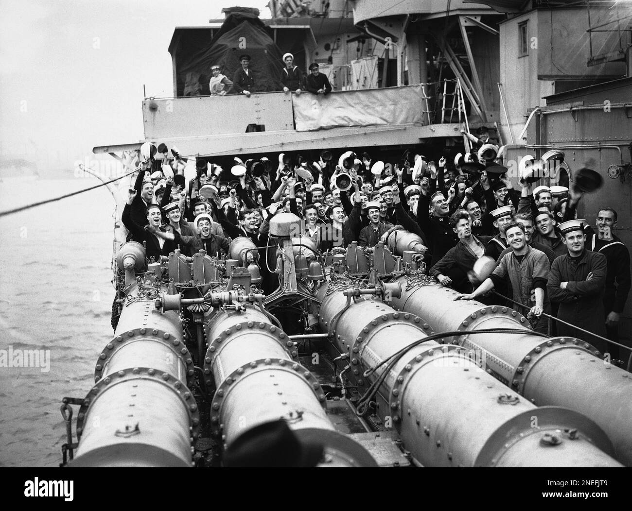 Cheering men of British heavy cruiser HMS Dorsetshire behind the ship’s ...