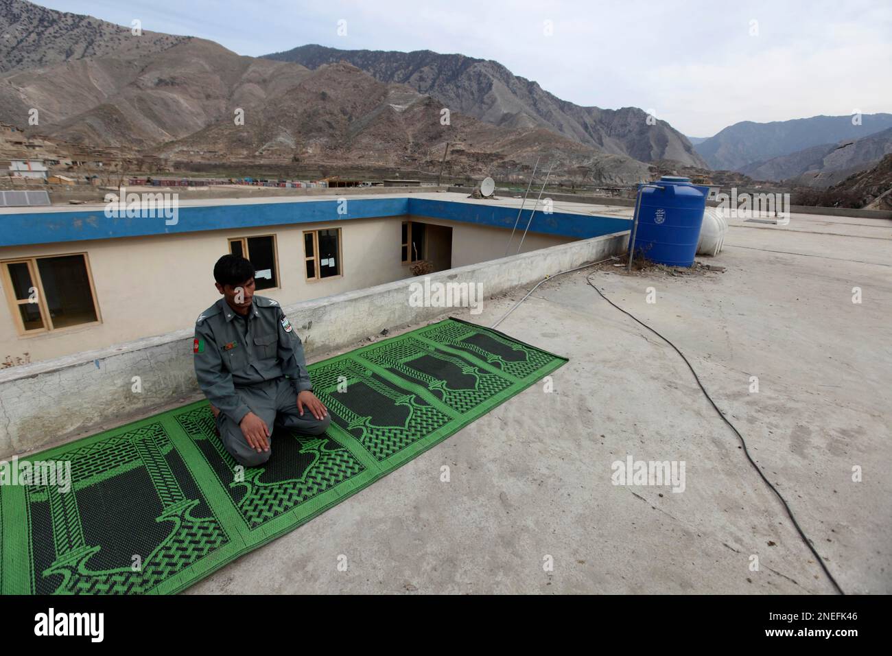 Afghan National Police officer Sadiqallah Khuaja prays on the roof of ...