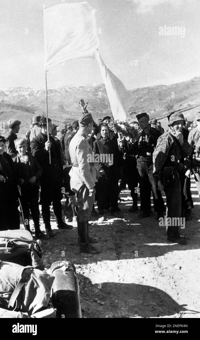 Greek peasants, looking rather disconcerted,welcome German soldiers ...