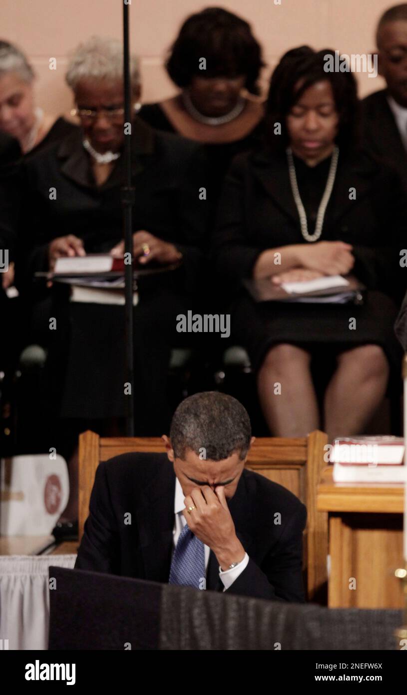 President Barack Obama, center, bows his head as he prays with ...