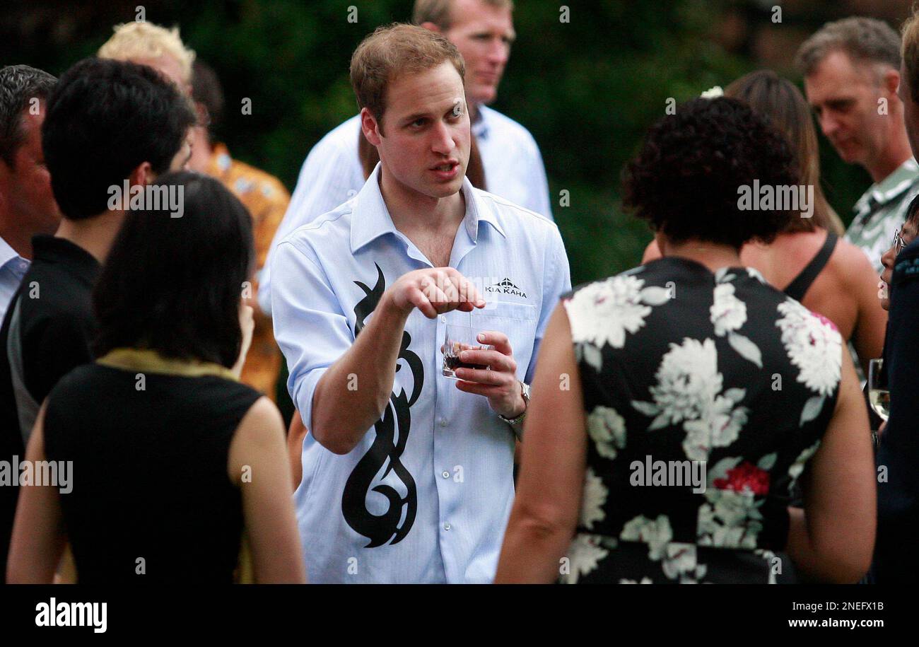 Britain's Prince William chats with guests with a drink in his hand ...