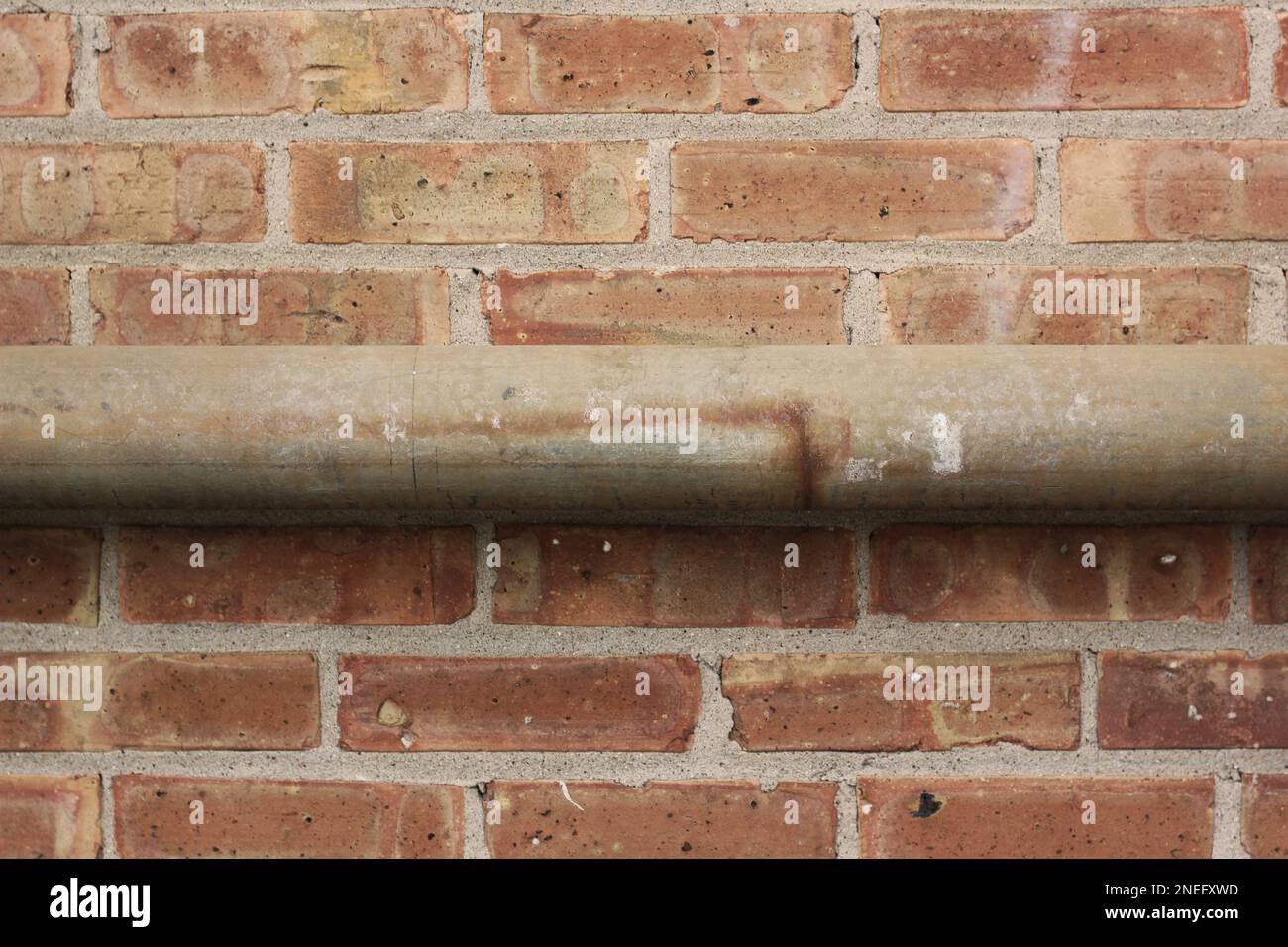 Typical common metal pipes running along a brick wall Stock Photo - Alamy
