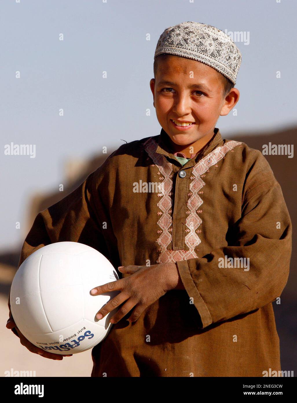 An Afghan boy plays with a ball given to him by the 293rd Military ...