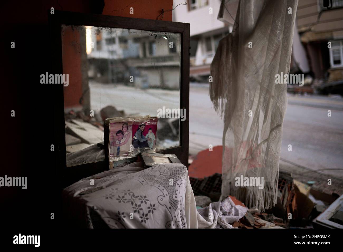 Photographs lie next to a mirror in the room of a destroyed house after ...
