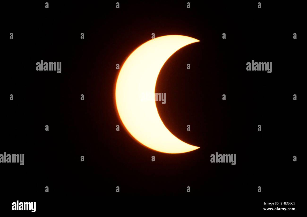 The moon begins to travel a path across the sun during a partial eclipse visible from Bangkok ...