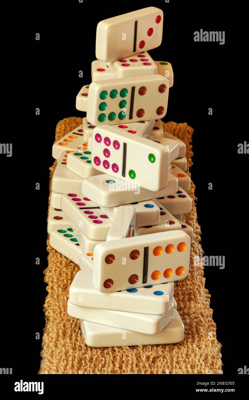 Dominoes with colorful dots are stacked high in a pile on a coco mat ...