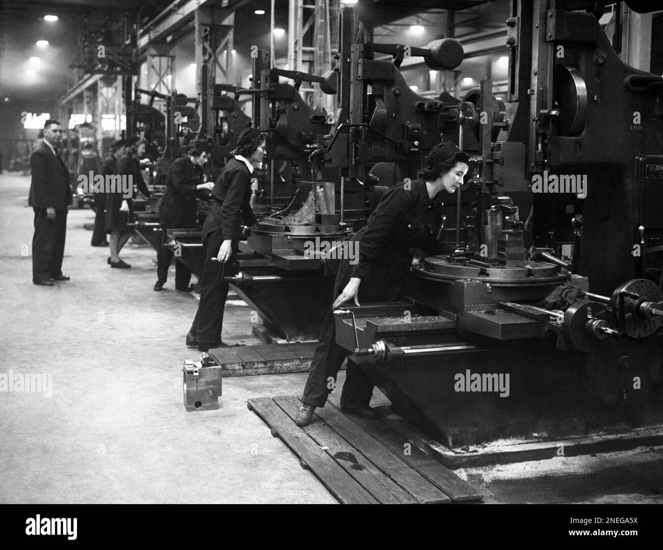 Girls manning machines producing parts for anti-tank guns at a Ministry ...