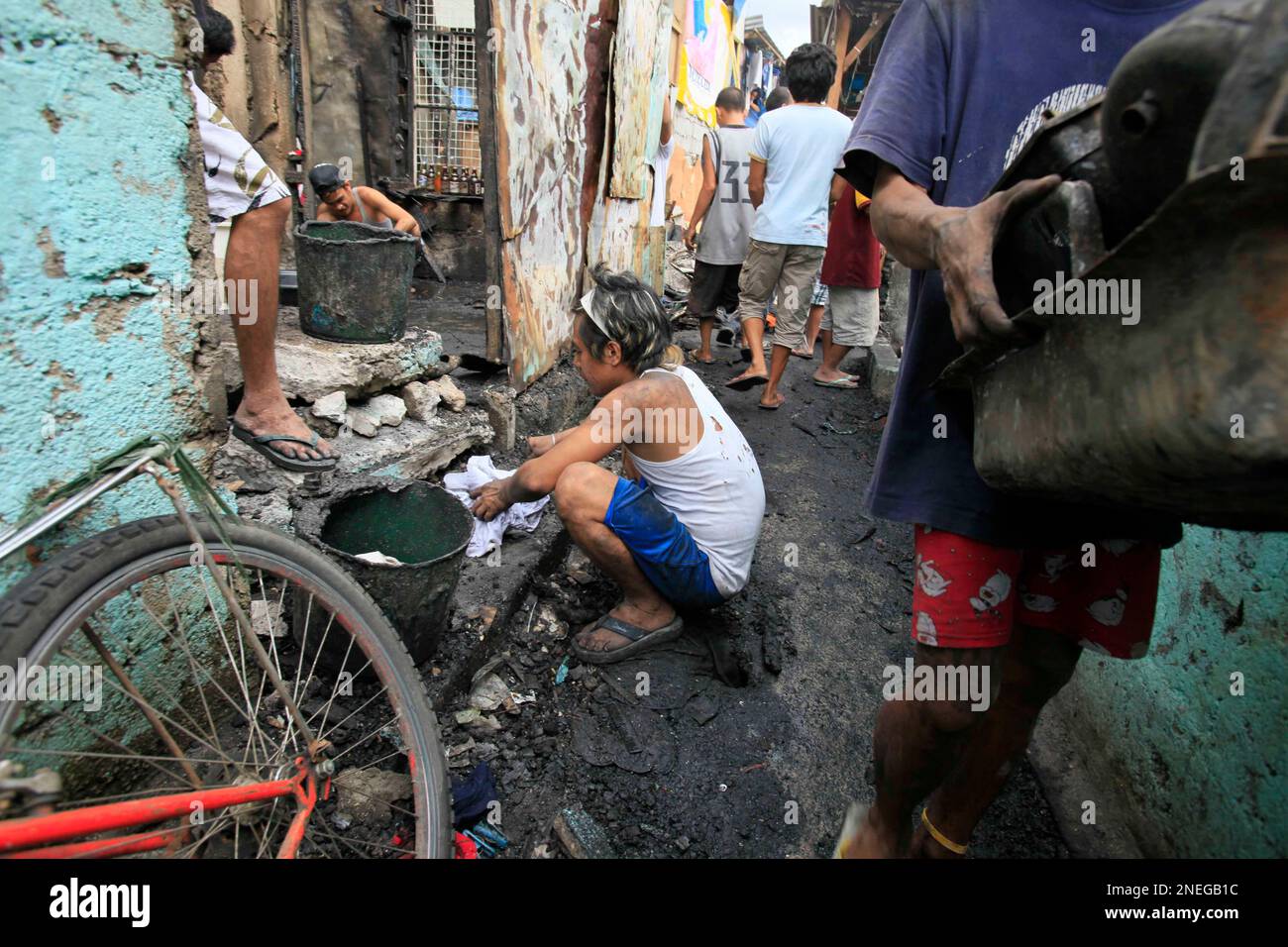 Residents sift through debris a day after a fire razed close to a ...