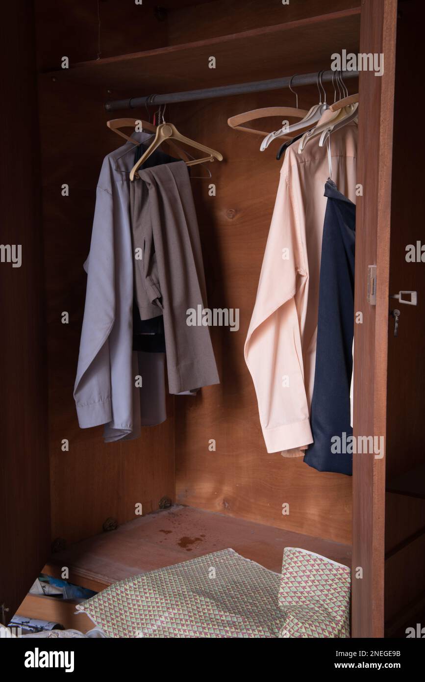 Abandoned messy bedroom with old used clothing on the ground and on the ...