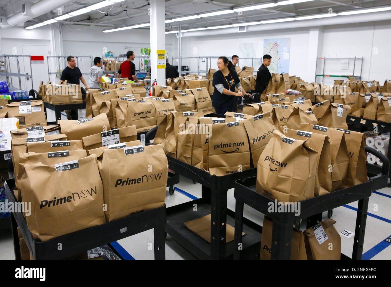 Carts full of orders are prepared to be wheeled out to the cars of ...