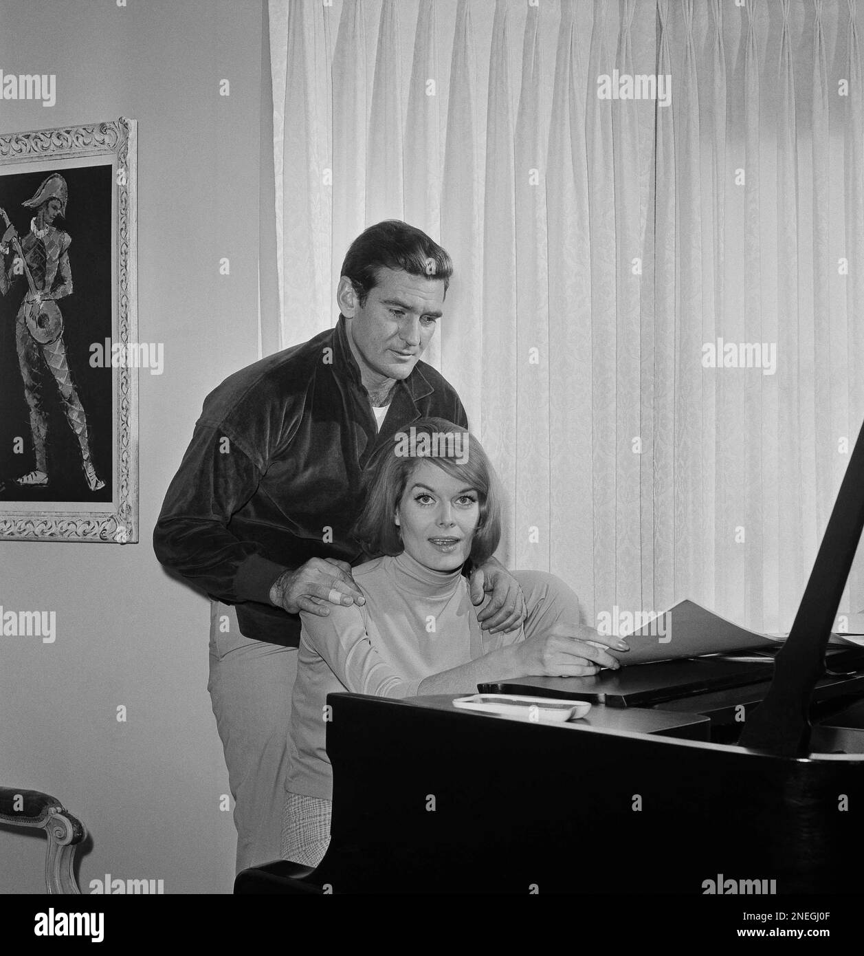 As Rod Taylor sings a with song, his wife Mary reacts with what may be ...